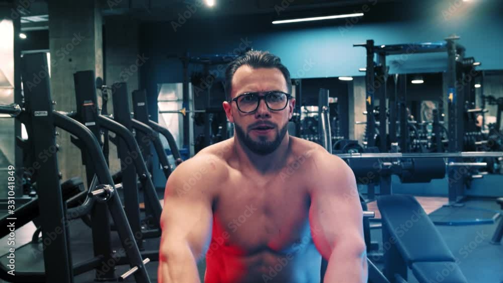 A bearded attractive man bodybuilder doing strength exercises in the ...