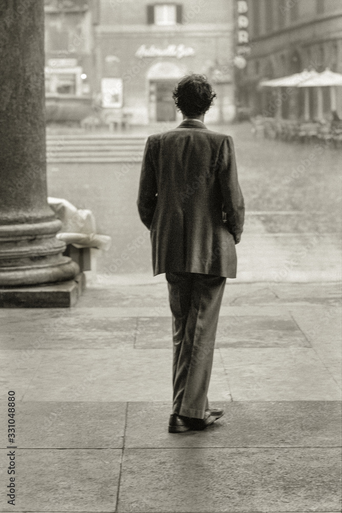 Rear view of man in suit waiting by column during rainy season Stock ...
