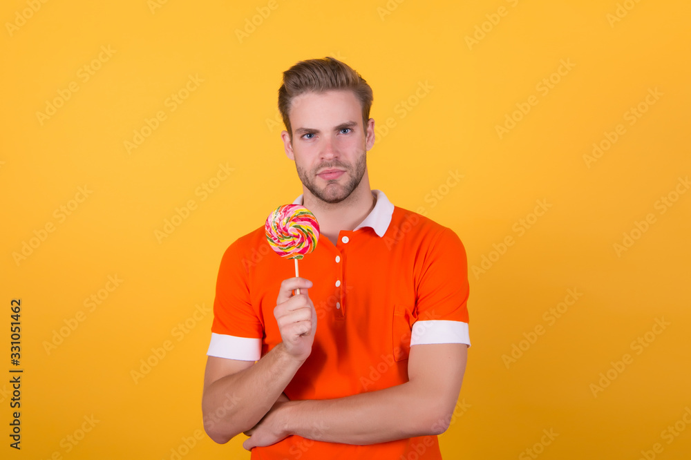 Cant wait to get a bite of lollipop. Young guy hold lollipop yellow ...