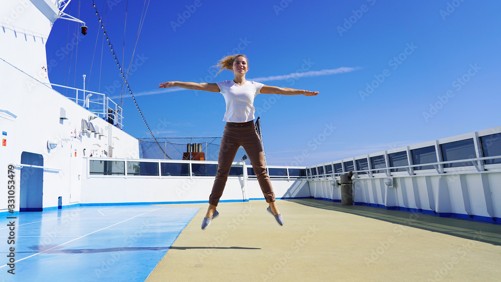 Stockfoto Beautiful sporty girl jumps up on the deck of a cruise ship ...