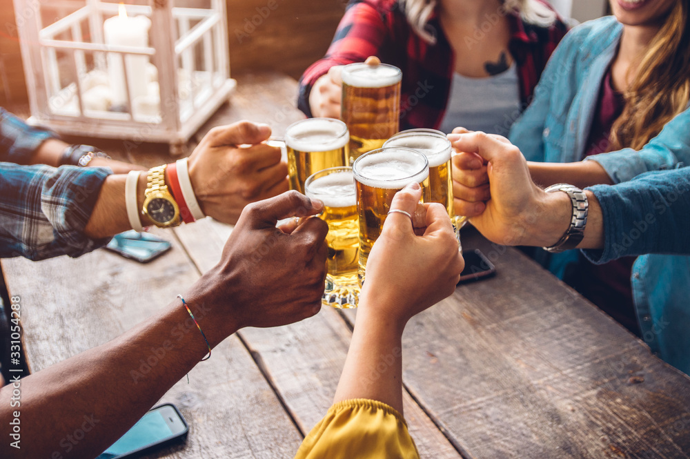 Group of people enjoying and toasting a beer in brewery pub ...