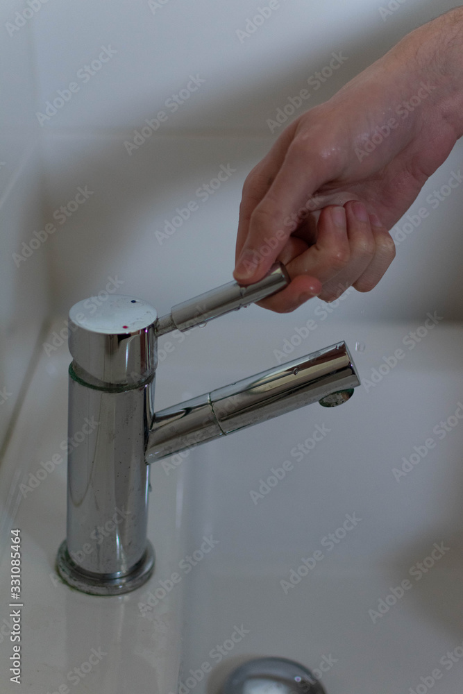 Mano cerrando el grifo Stock Photo | Adobe Stock