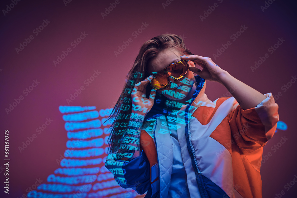 Energetic young female model posing in holographic sunglasses in vivid ...