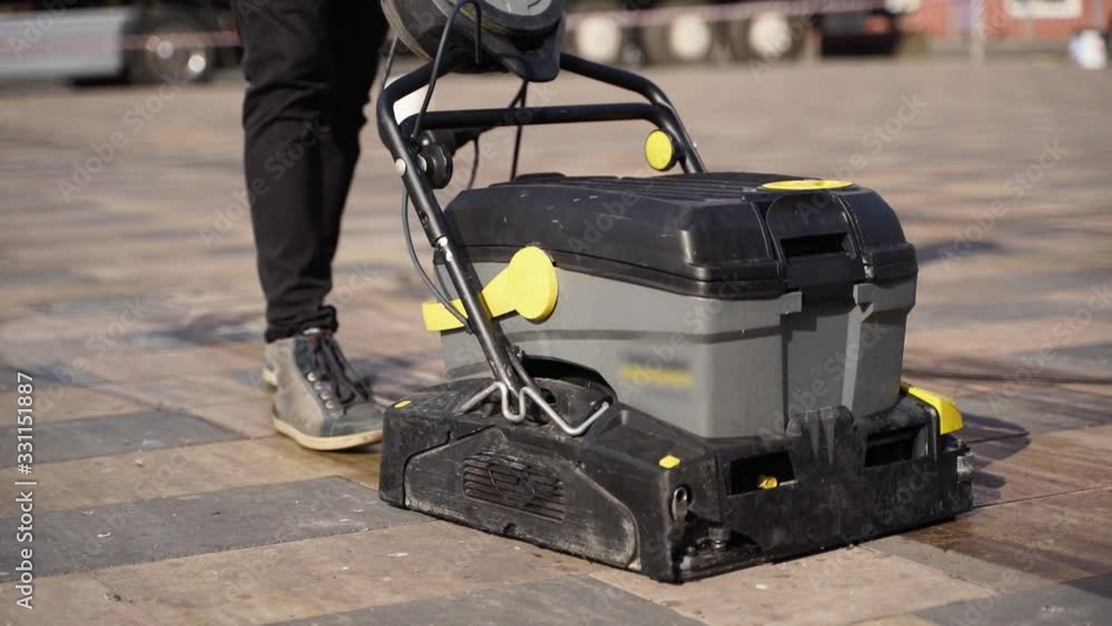 Janitor uses manual electrical push sweeper car and cleaning city ...