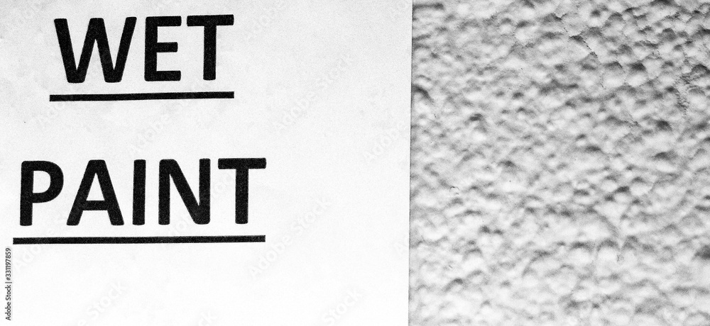 Wet Paint sign, black and white/monochrome sign against a rough ...