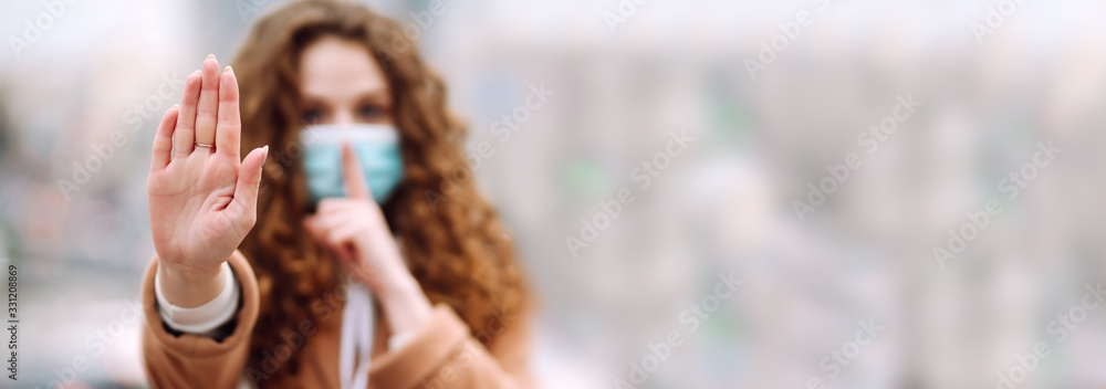 long edge.Stop sign, Woman in a sterile medical mask on her face, looks ...
