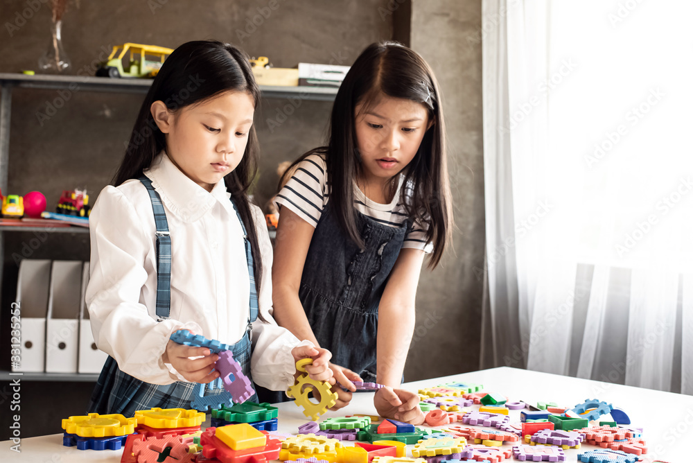 Two little girl playing colorful lego on desk with interested feeling ...