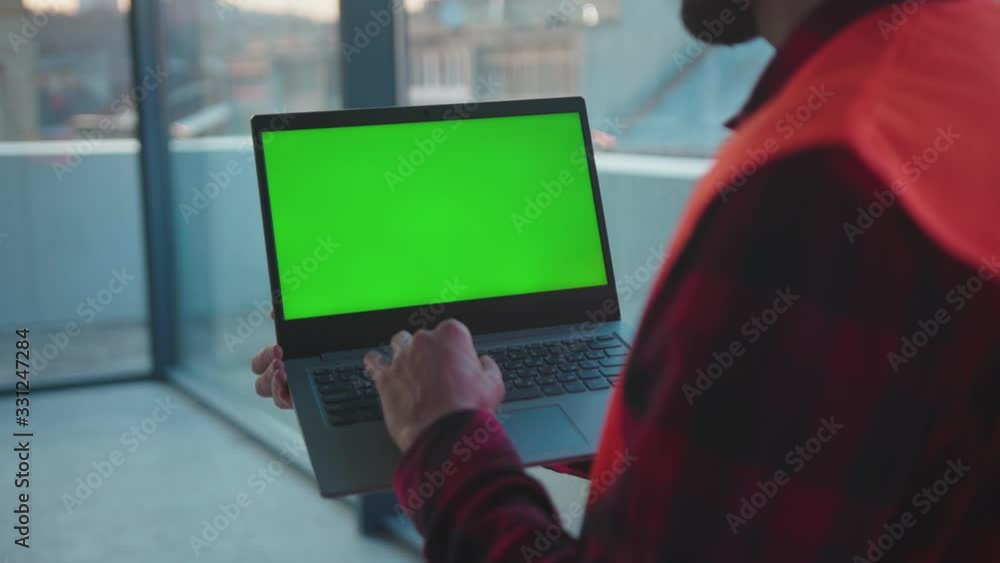 Man engineer stand using laptop computer with green screen inside ...