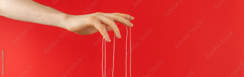 puppeteer's hand with ropes on fingers control the people mind concept ...