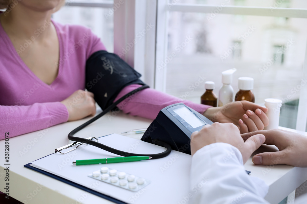 Male doctor measures the pressure with the device to the patient Stock ...