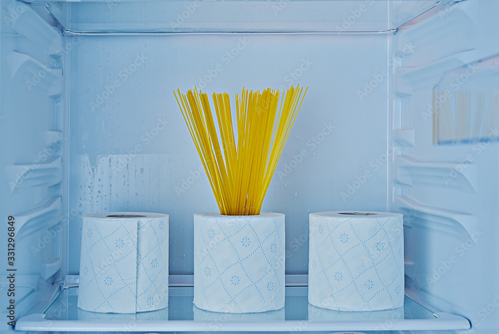 Rolls of toilet paper and spaghetti on shelves in fridge as symbol of ...
