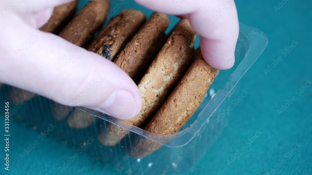 Vidéo Stock Oatmeal cookies lie in transparent open plastic tray. Male ...