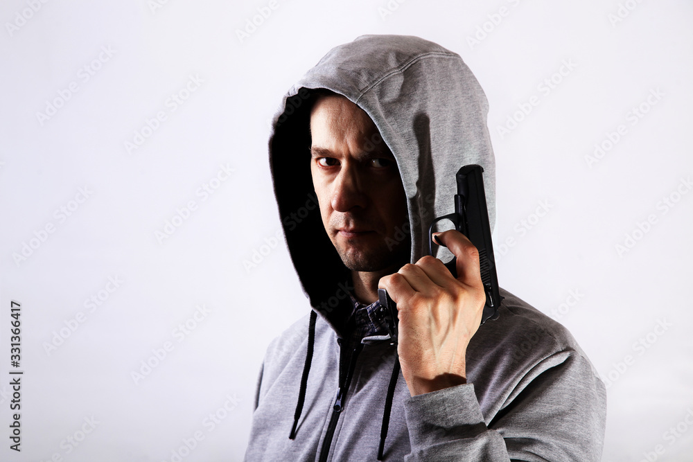 Fearful man holds gun and hood on head in hand, major plan Stock Photo ...