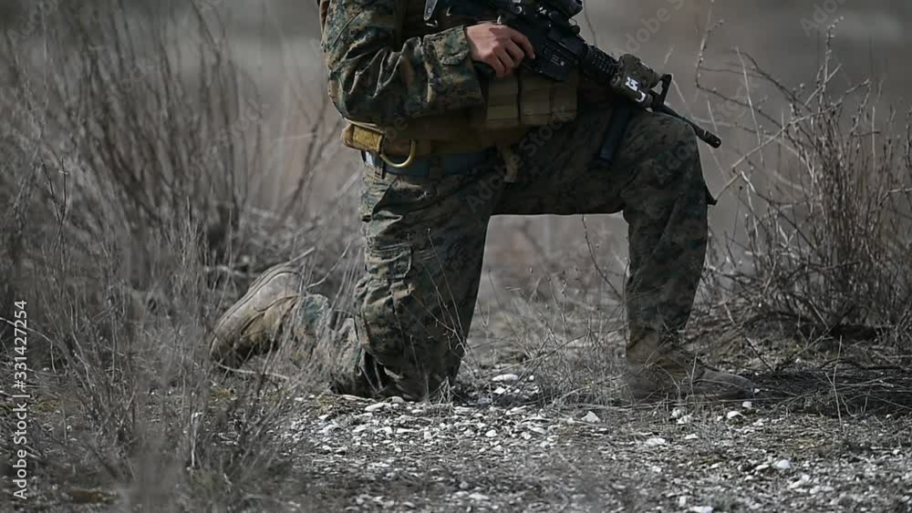 US army soldier holding automatic rifle in defense position during ...