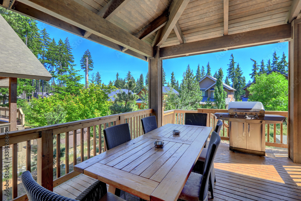Beautiful covered deck with large luxury dining room table with grill ...