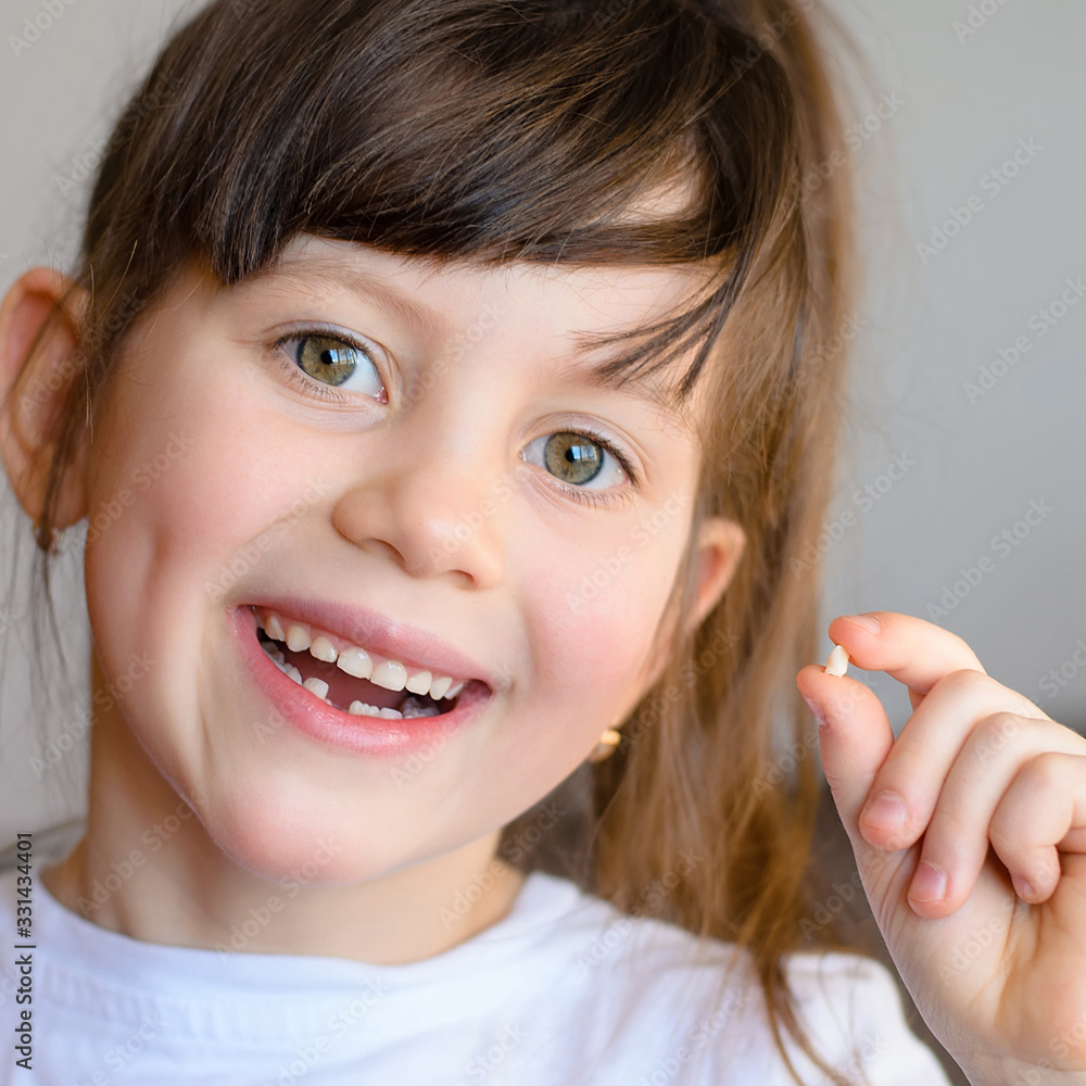 Foto de Cute preschooler showing her milk tooth fell out and her ...