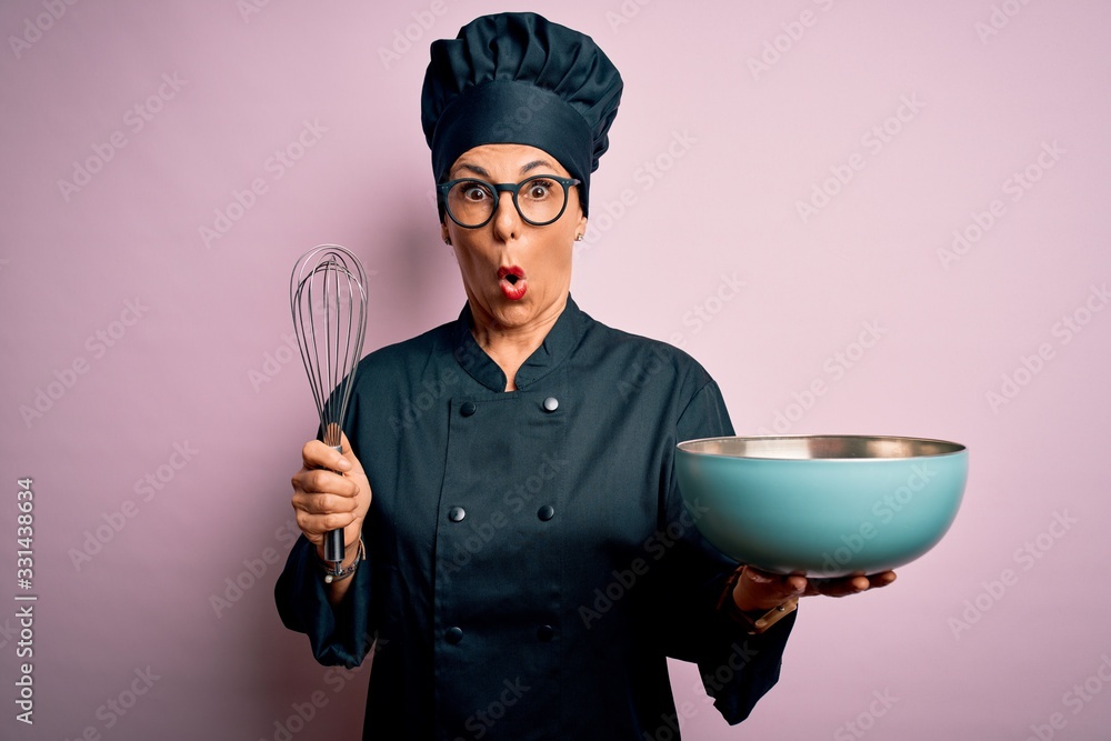Middle age brunette chef woman wearing cooker uniform and hat using ...