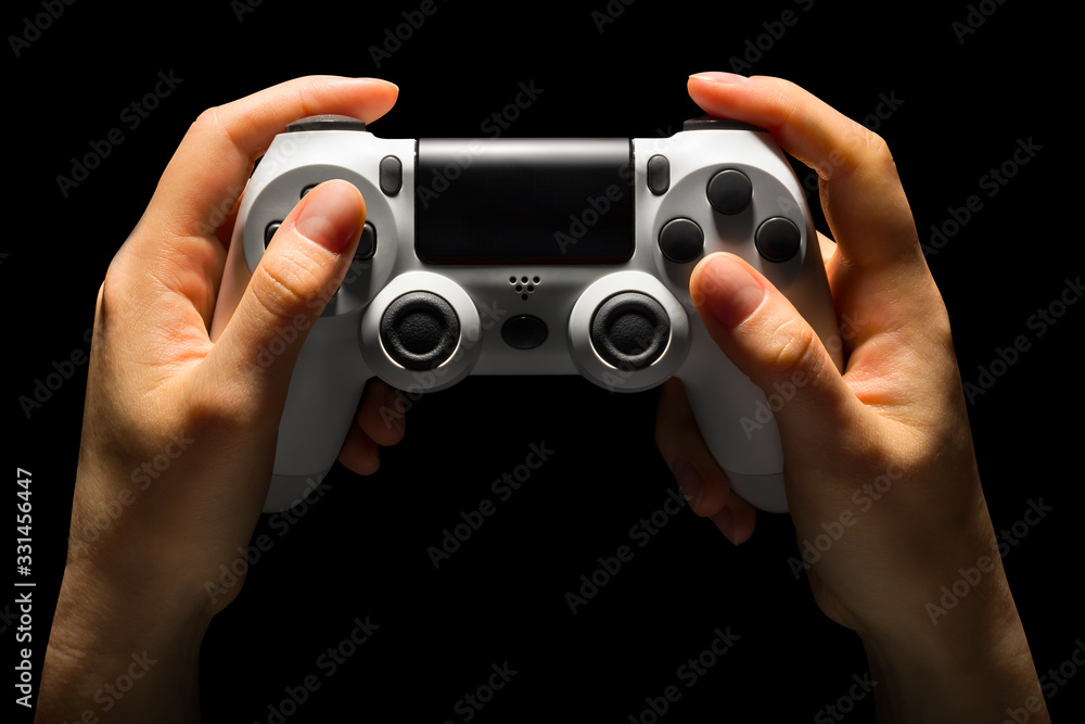 Hyman hands holding white video game gamepad isolated on a black ...