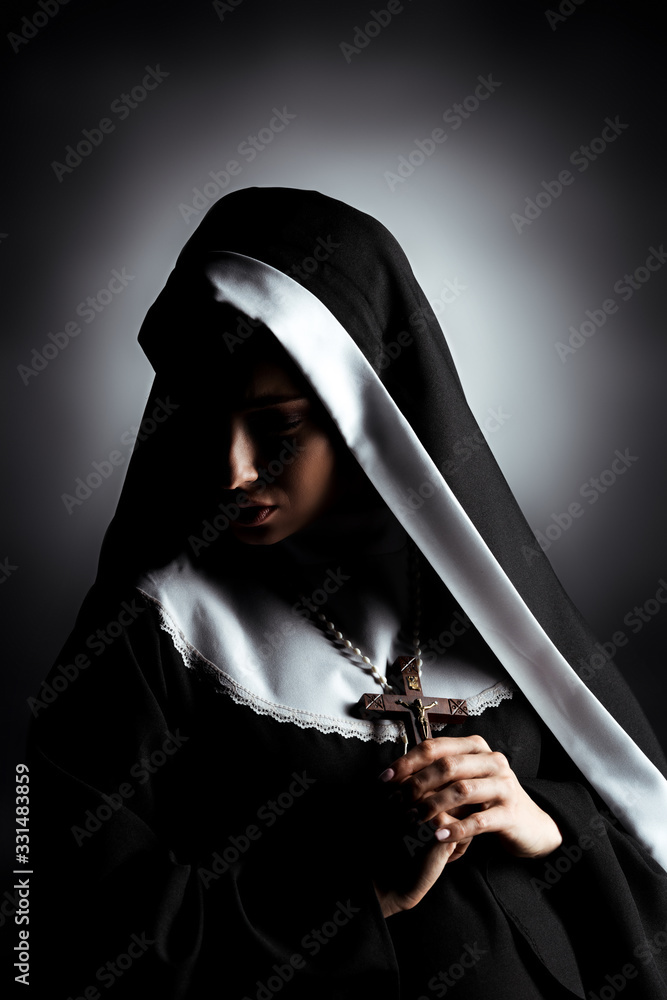 beautiful young sad nun holding cross on grey Stock Photo | Adobe Stock