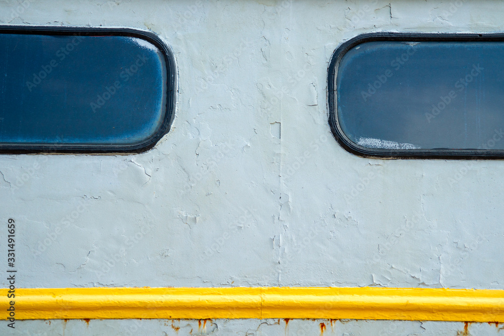A metal side wall of a vintage diesel engine locomotive painted grey ...