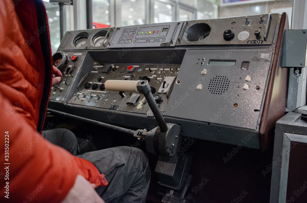 subway train cabin and dashboard. Hand of subway driver on the lever of ...