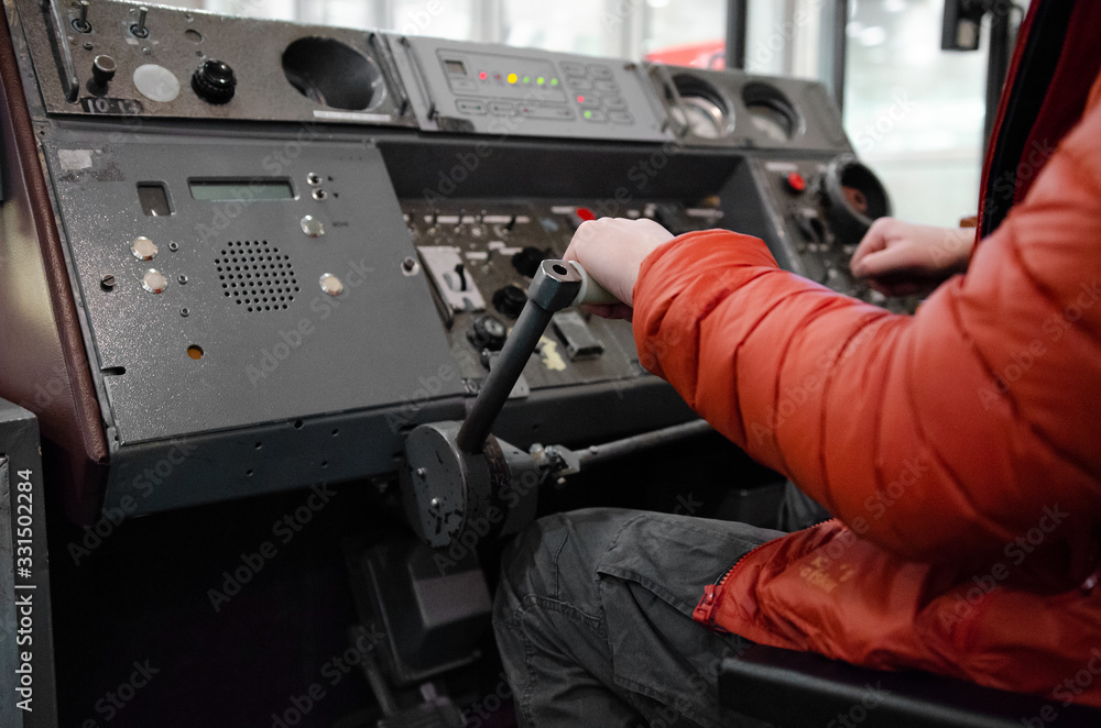 subway train cabin and dashboard. Hand of subway driver on the lever of ...