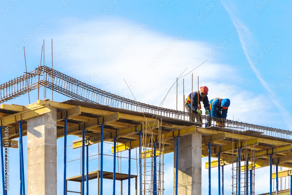Two workers install a metal frame for a reinforced concrete beam Stock ...