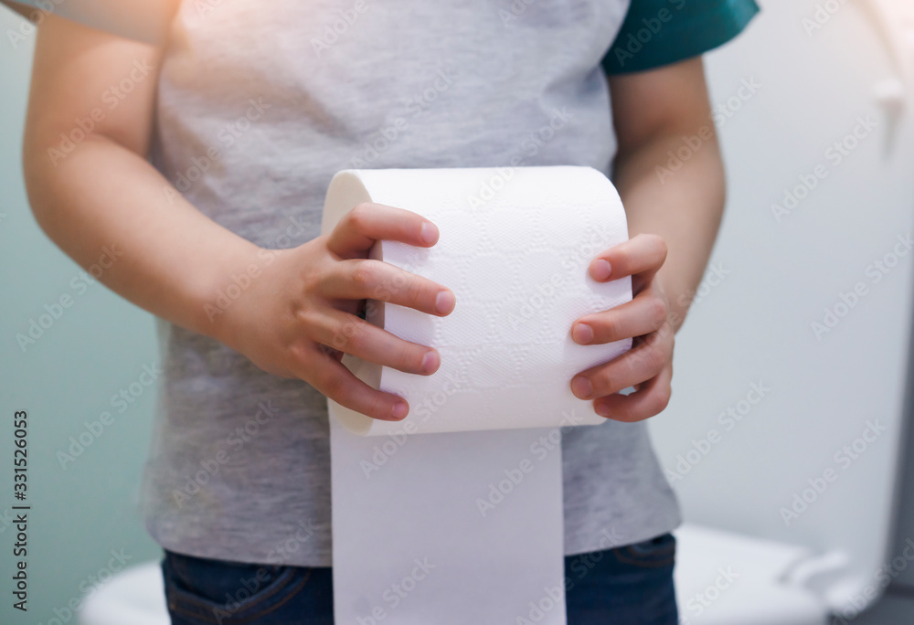 Cropped shot of kid hands holding toilet roll, little boy suffers from ...