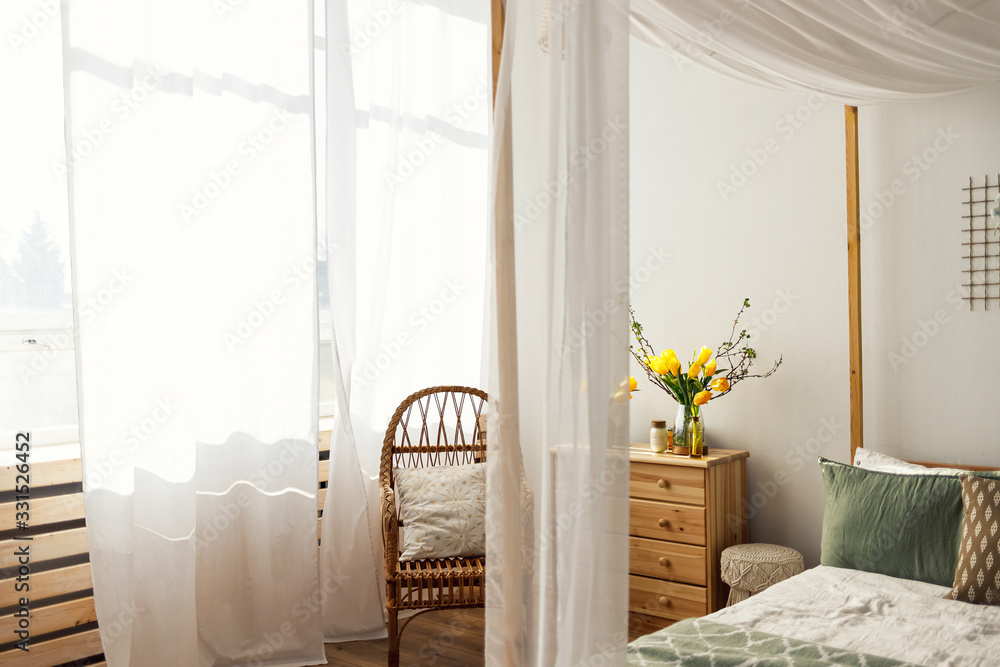 Bright sunny bedroom interior. Eco cotton linen and blanket on a bed in ...