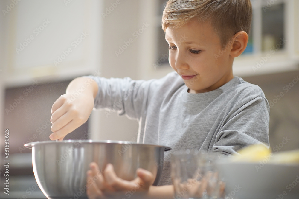 Child cooking at the kitchen. White boy stirring dough for a cookie ...