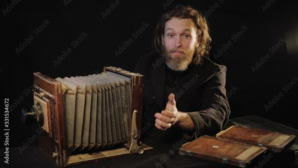 Vidéo Stock Bearded photographer in black clothes of 19th century, make ...