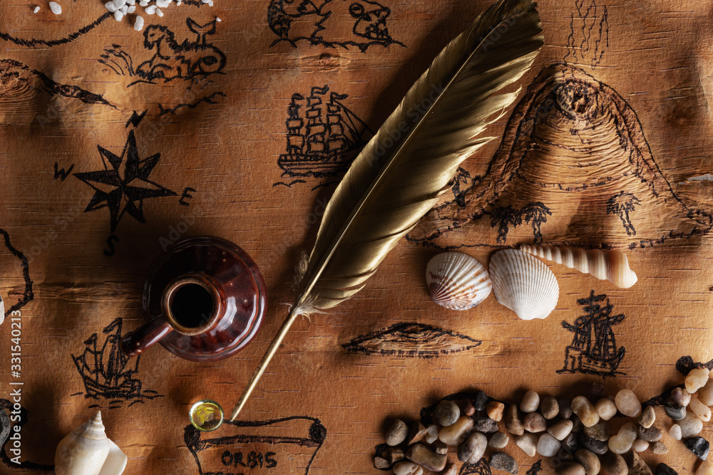 Gold quill pen on sea map with illustrations of sailing vessels and ...