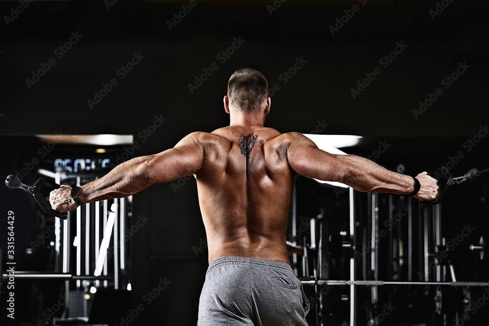 A man trains his arms and chest in the gym on the simulator, does ...