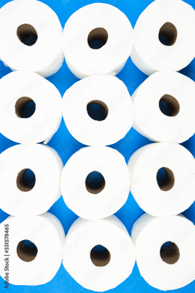 Background pattern of toilet paper rolls lay flat on the bright blue ...
