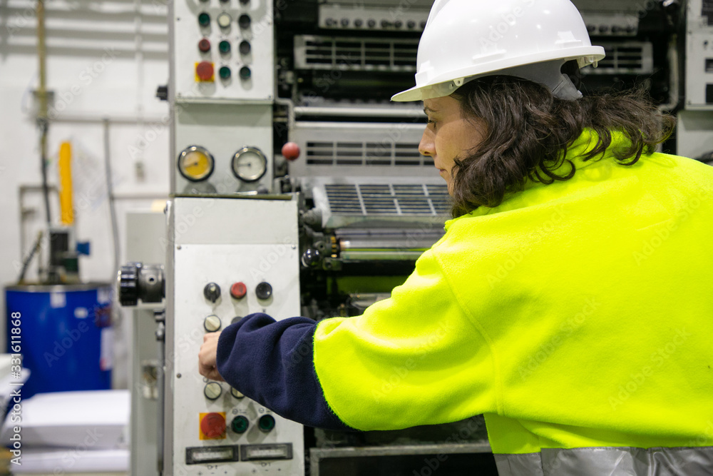 Professional operator working with printing machine. Confident mature ...