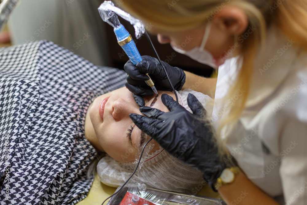 Microblading eyebrows work flow in a beauty salon. Woman having her eye ...