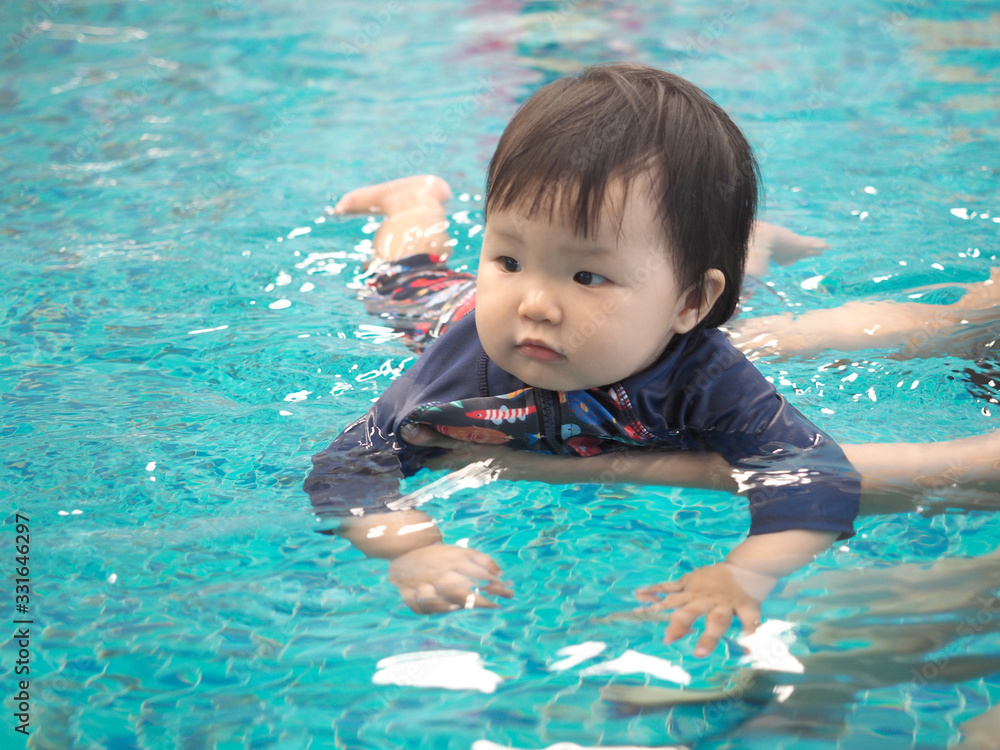 Asian cute baby infant and pretty asian woman are swimming in the pool ...