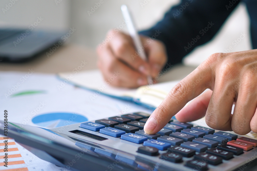Businessman working on desk office with using a calculator to calculate ...