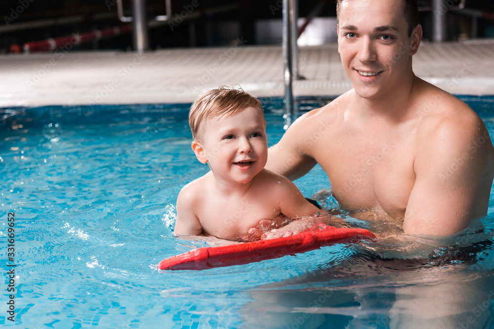 happy swim coach teaching cheerful toddler kid with flutter board in ...