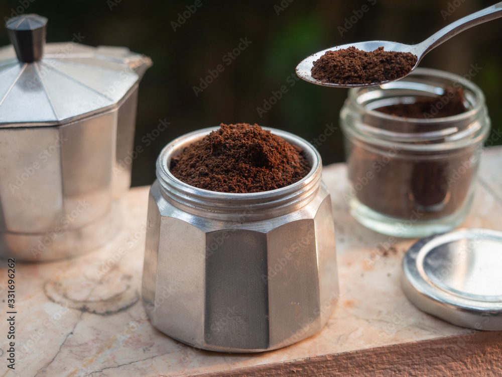 Adding ground coffee in moka pot Stock Photo | Adobe Stock