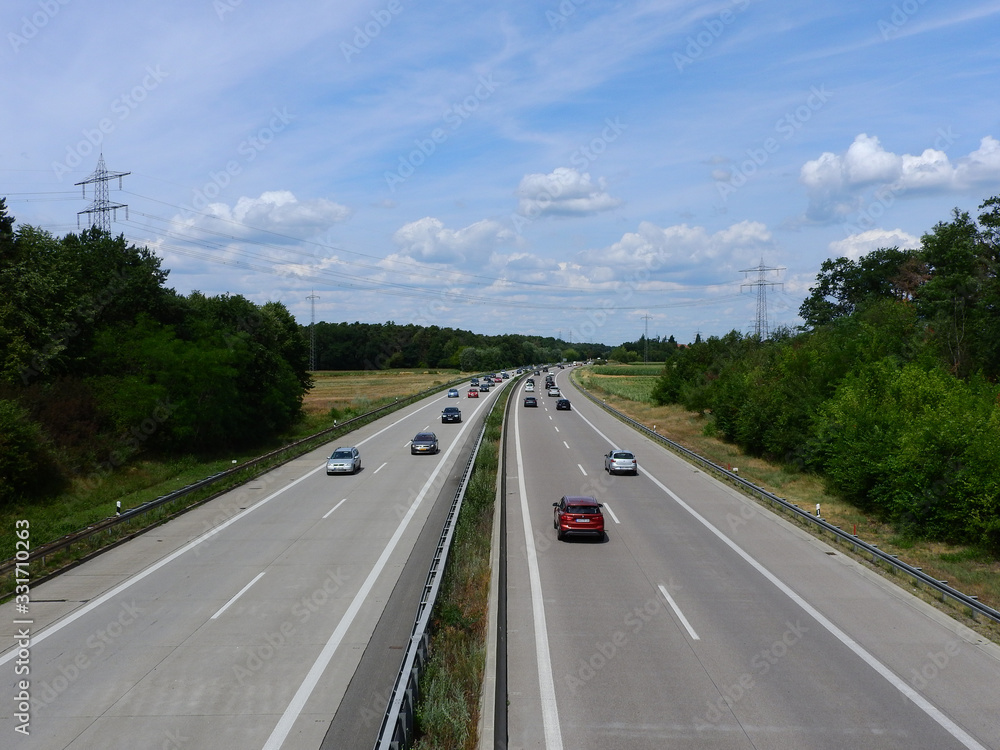 German Autobahn/Highway with cars on a sunny day and high voltage ...