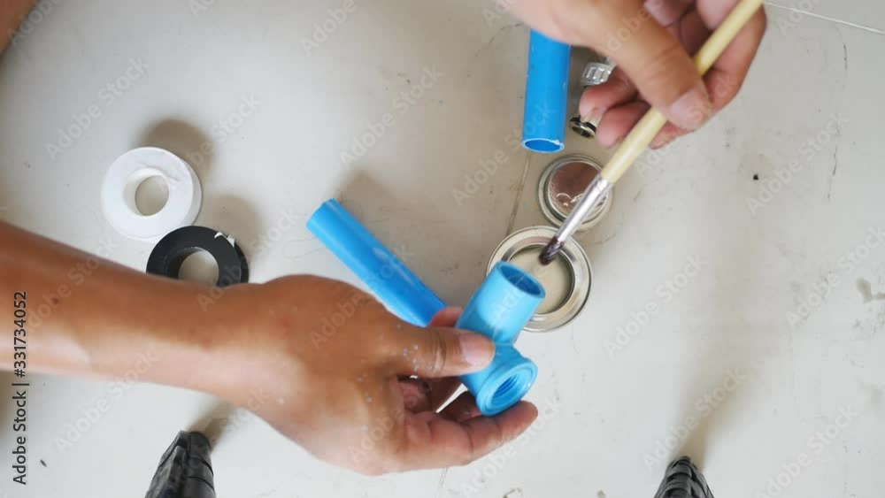 The plumber is assembling the water pipes by connecting the water pipes ...