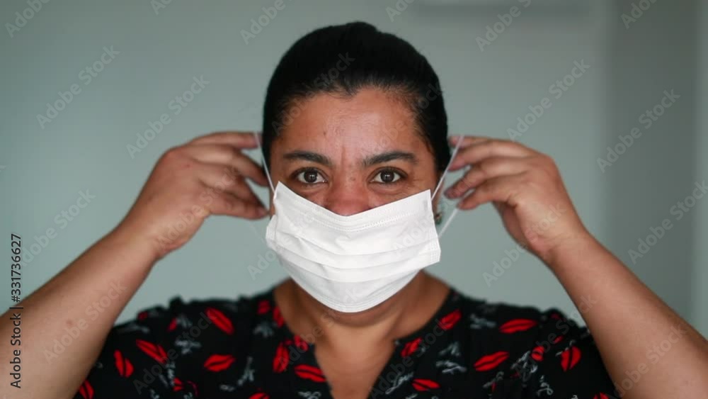 African american black woman putting on face mask for protection ...