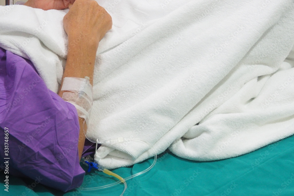 Unconscious surgical patient sleeping on bed at hospital being injected ...