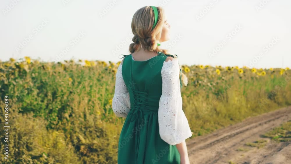 Young beautiful rustic woman turned away walking on road backdrop ...