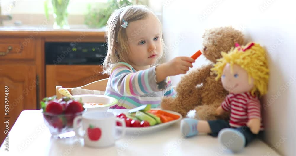 Vidéo Stock Adorable toddler girl eating fresh fruits and vegetables ...
