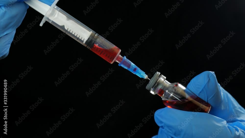 Vidéo Stock doctor's hand holds a syringe and a red vaccine bottle at ...