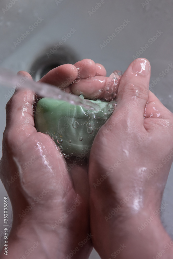 Fotka „people washing hands in sink with a bar of soap to kill ...