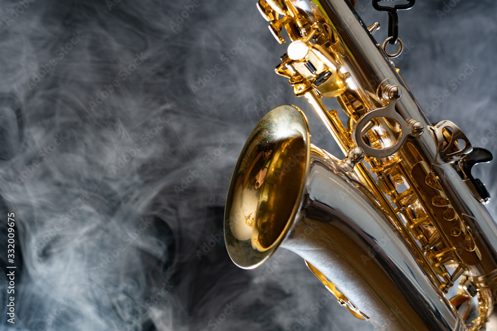 Golden shiny alto saxophone on black background with smoke. copy space ...