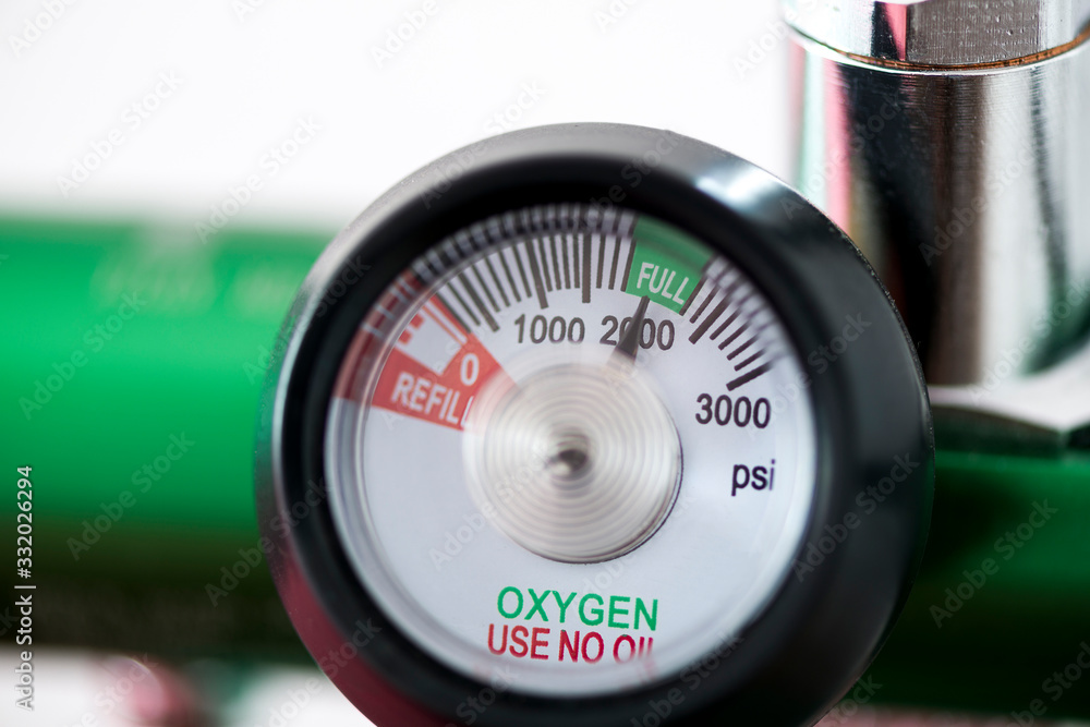 Detail of an oxygen pressure gauge and cylinder with white background ...